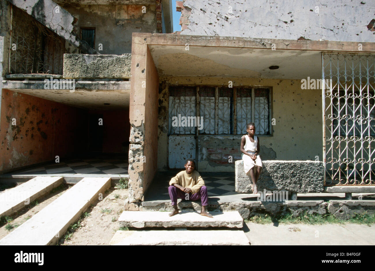 Civil war aftermath, displaced homeless people outside damaged building ...