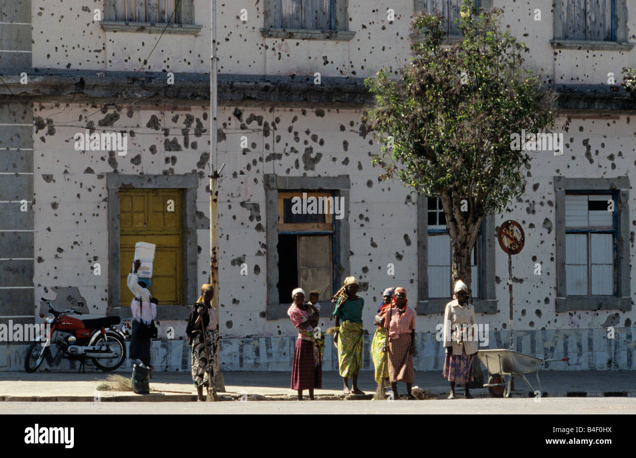 Women standing in front of bullet-riddled building in Angola Stock ...
