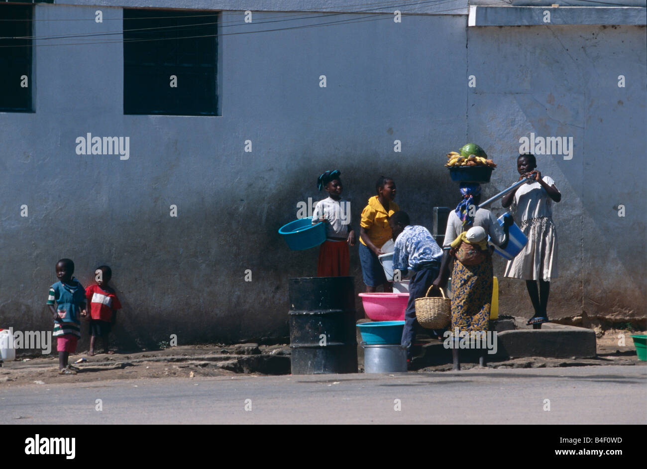 People filling water from pump on street in war-ravaged Angola Stock ...