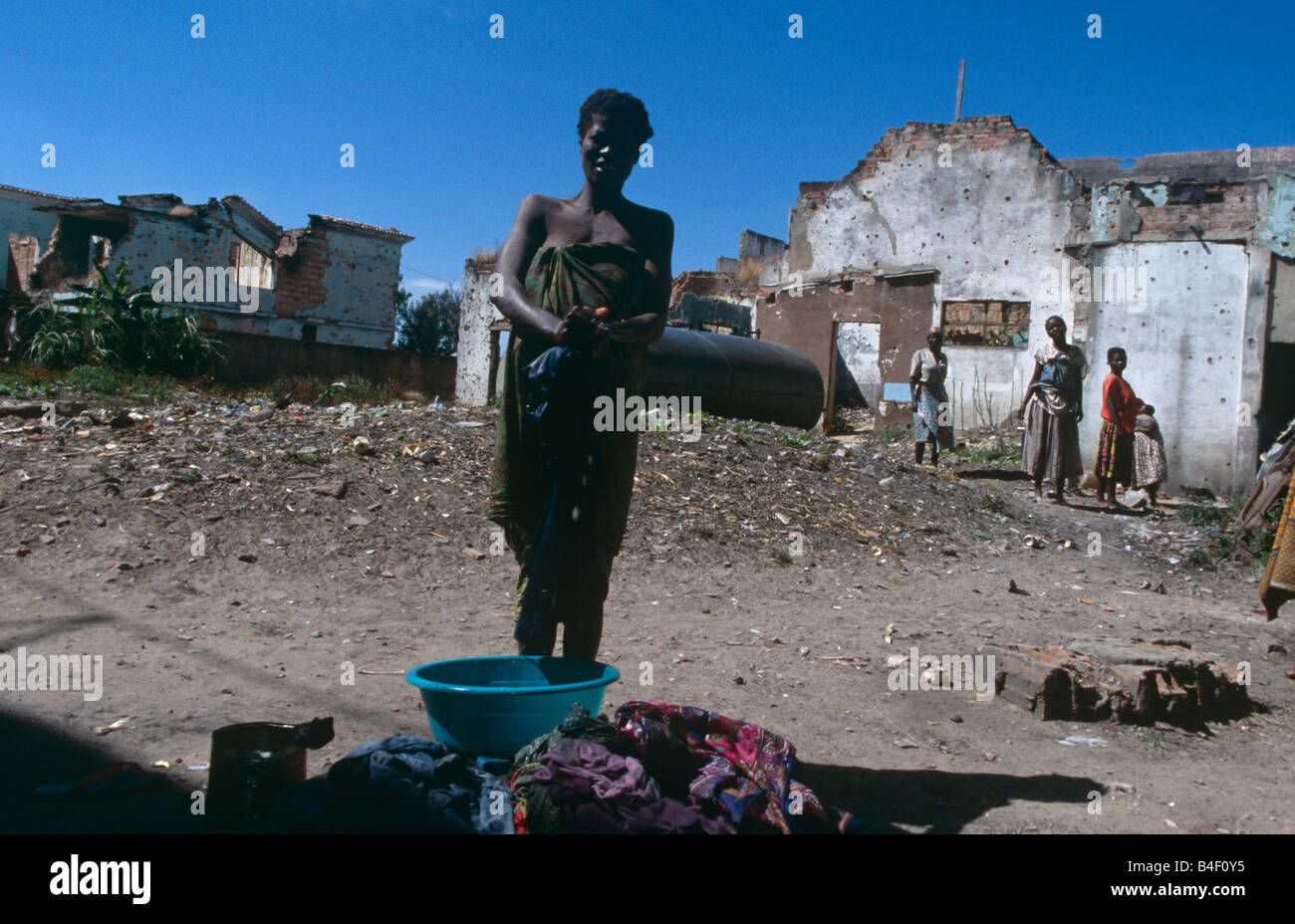Internally displaced people sheltering in the midst of ruined buildings ...