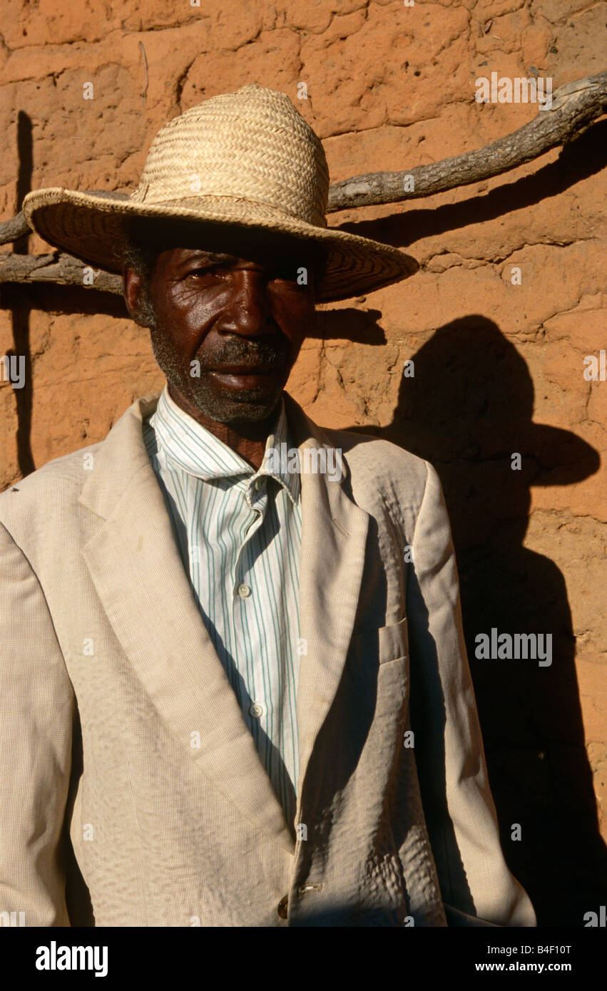Stylish man in front of sunlit wall wearing straw hat, portrait, Angola ...