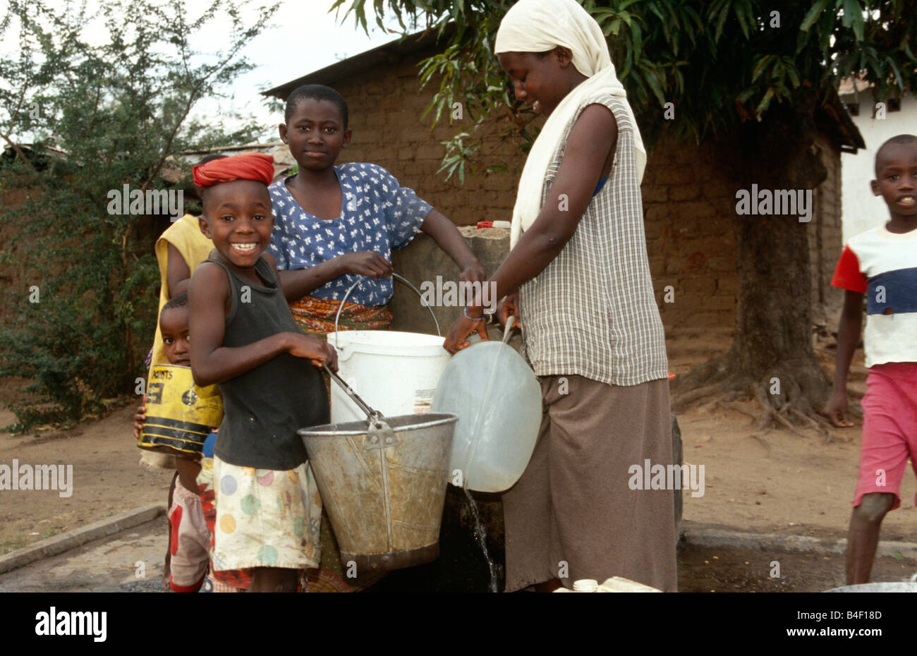Children collecting water in village, Burundi Stock Photo - Alamy