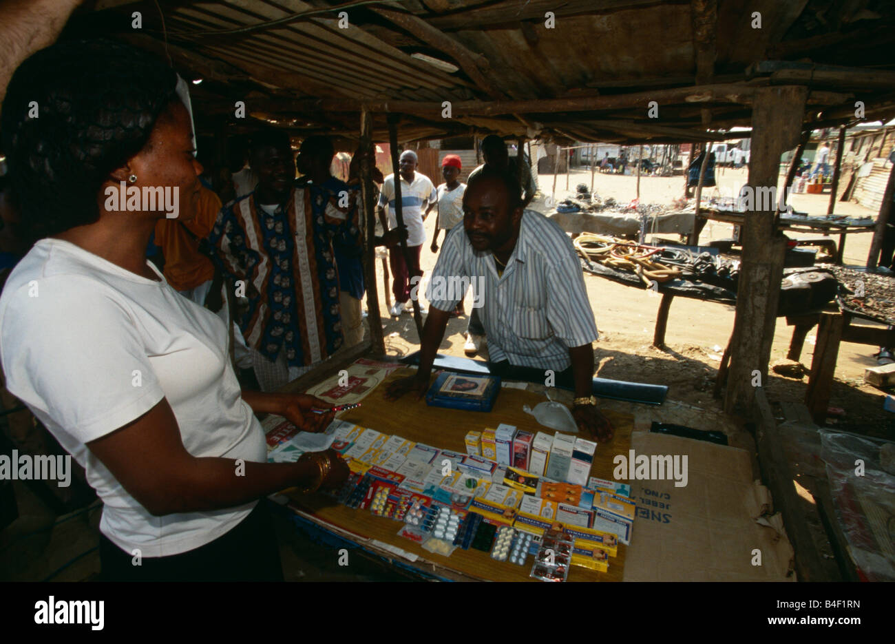 Customer talking to vendor selling medicines in market, Angola Stock ...