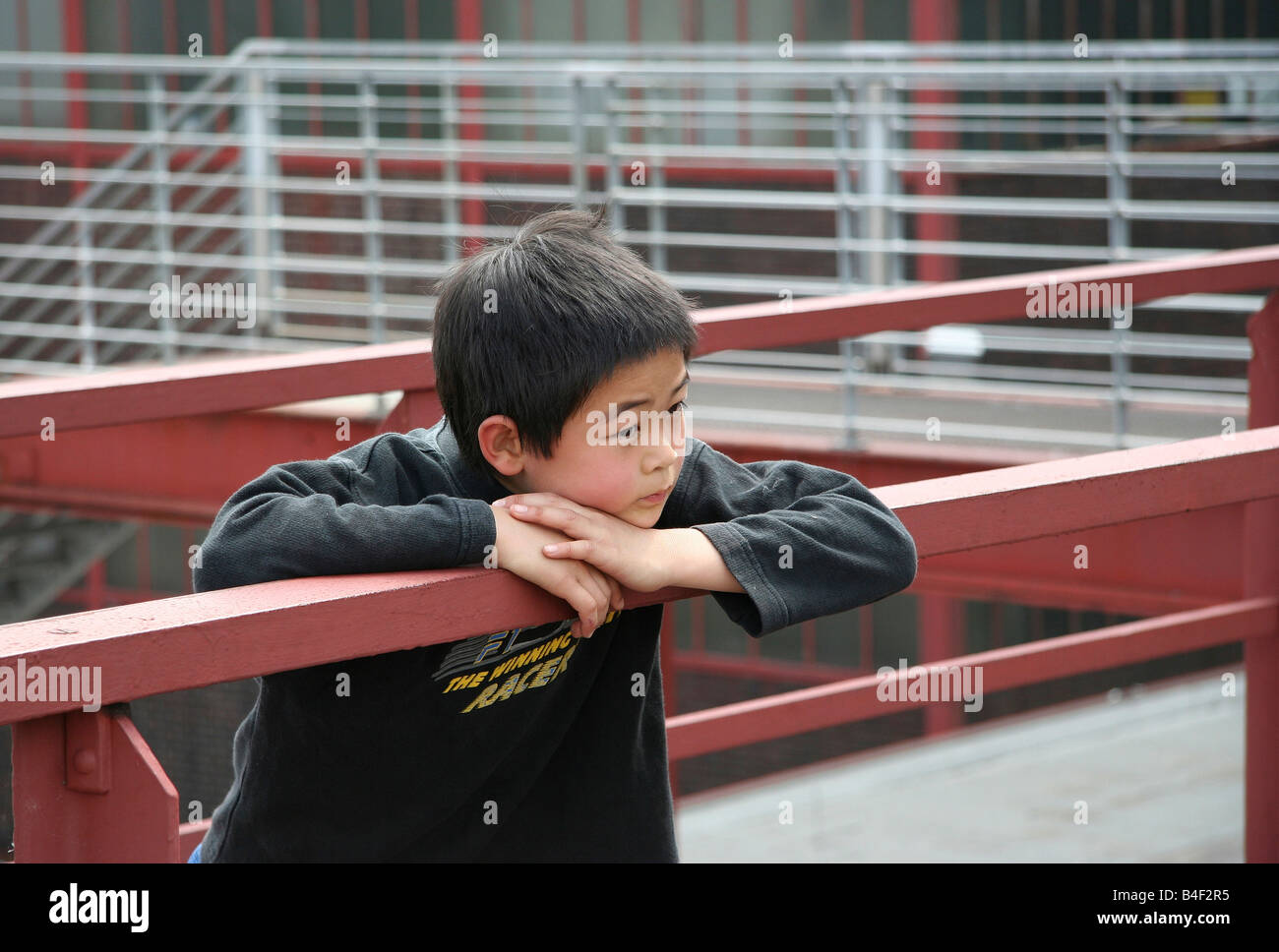 lonely boy daydreaming and leaning against a banister Stock Photo - Alamy