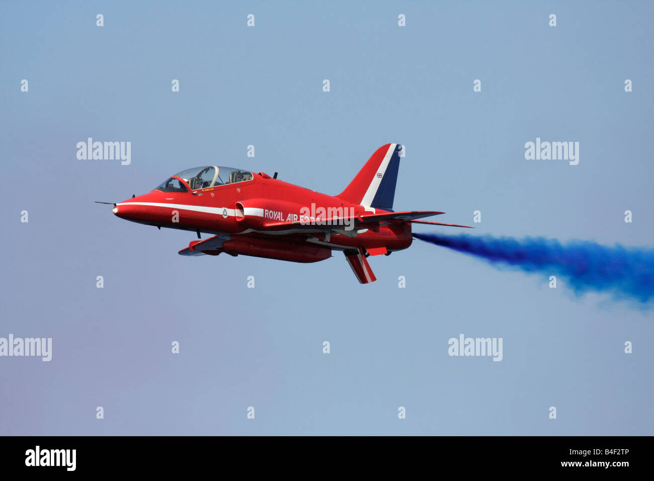 Royal Air Force Red Arrows Hawk jet flying and trailing blue smoke ...