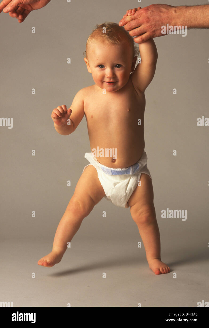Baby walking hand in hand hi-res stock photography and images - Alamy