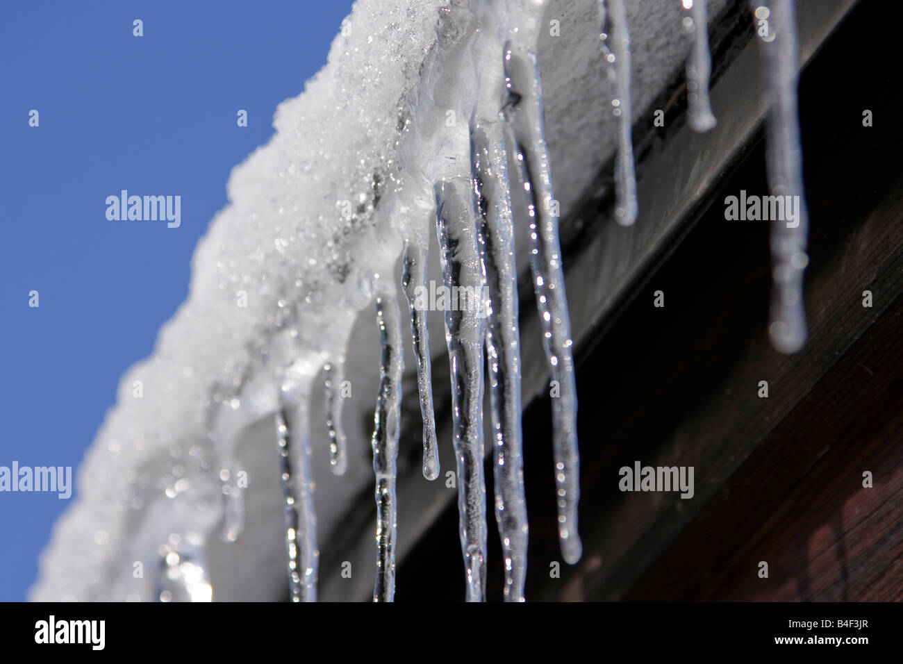 Icicles hanging from a roof Stock Photo - Alamy