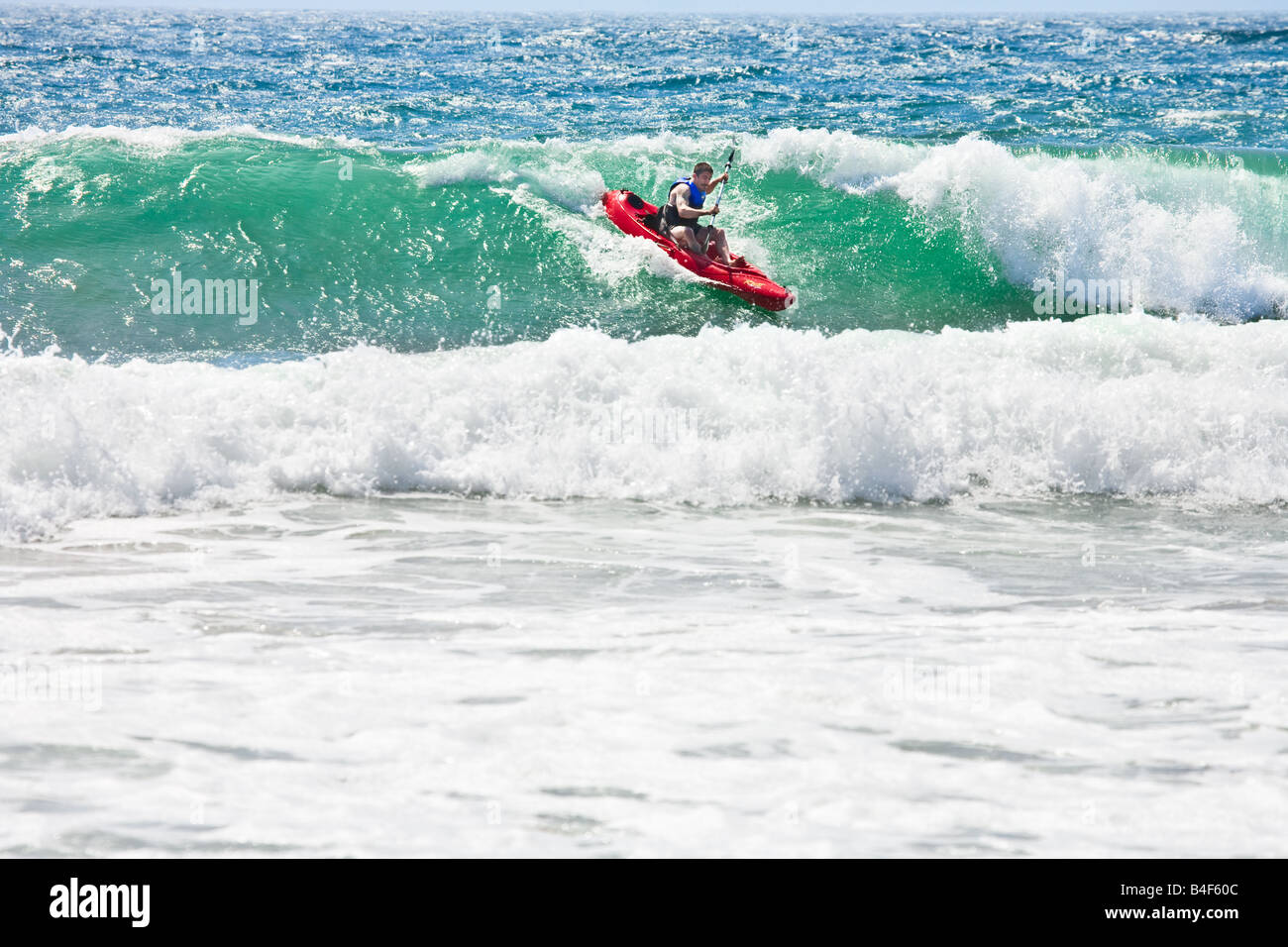 A kayaker riding a huge big wave in the ocean Stock Photo - Alamy