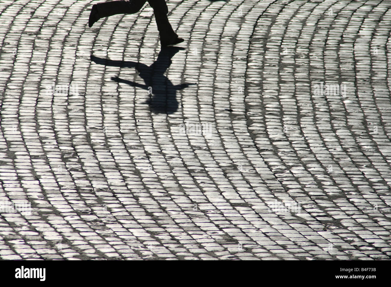 one person running on cobbled street in city town Stock Photo - Alamy