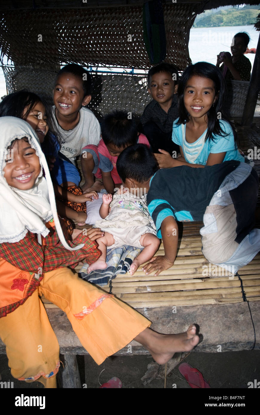 a group of childreen looking after a very little baby in a poor little ...