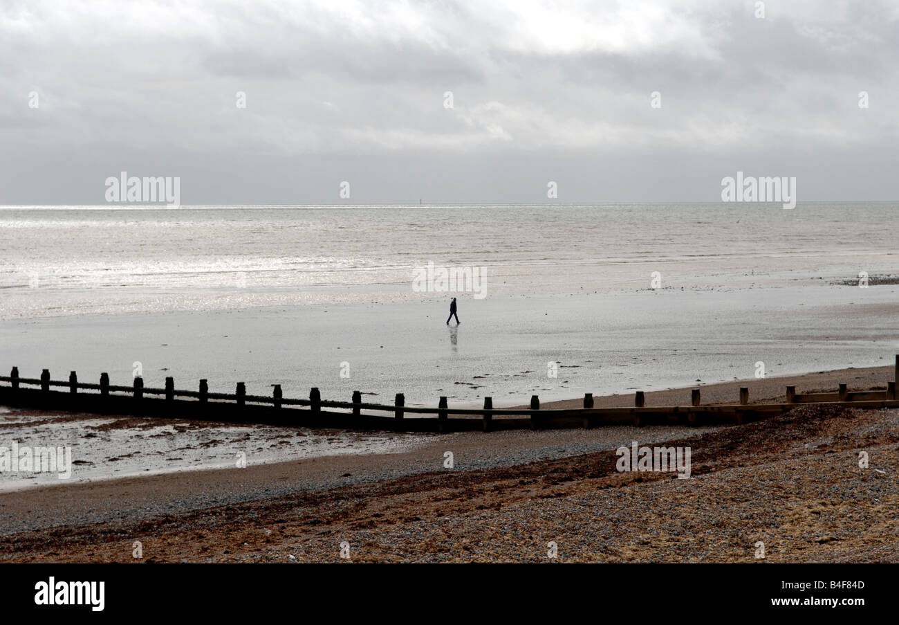 Lone figure walking on the beach at Ferring in West Sussex Stock Photo ...