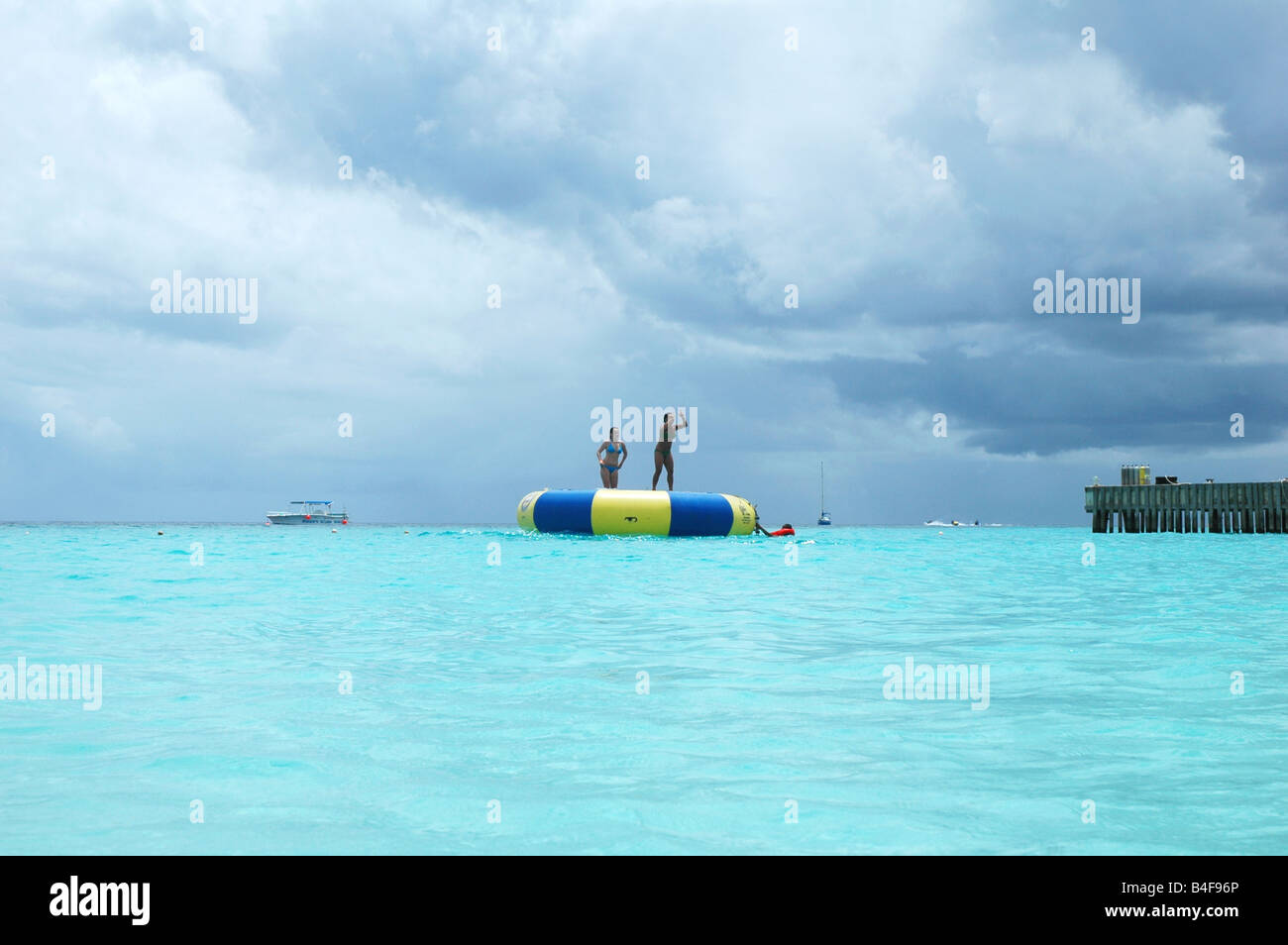 people playing on floating innertube raft carlisle bay beach caribbean ...