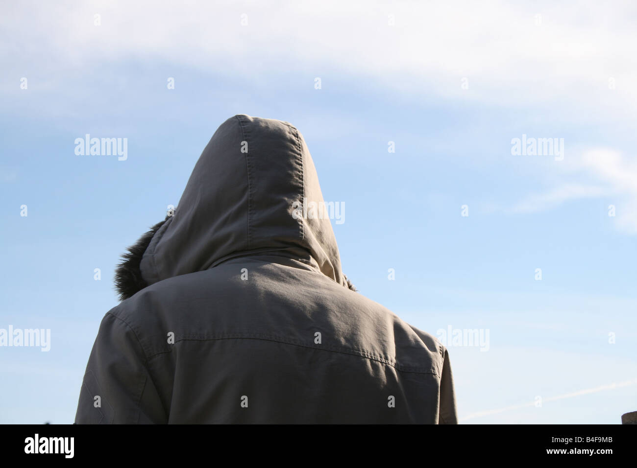 person wearing hood coat jacket and blue sky Stock Photo - Alamy