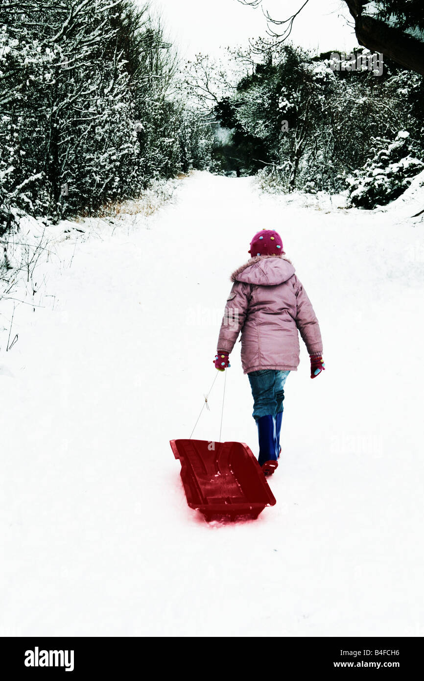child pulling red sledge Stock Photo - Alamy