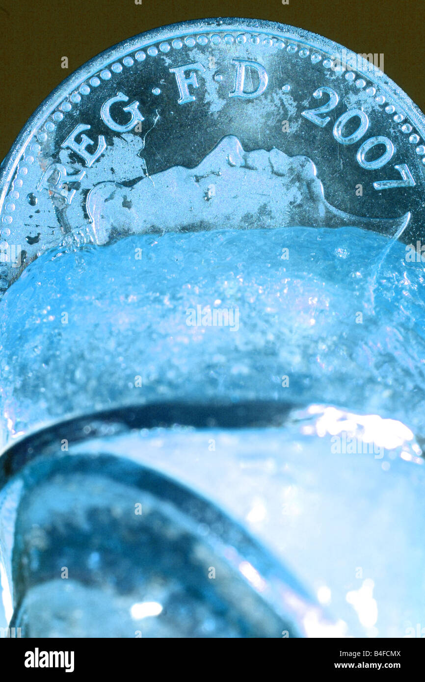 Frozen assets coin money cash in ice block financial freeze concept ...