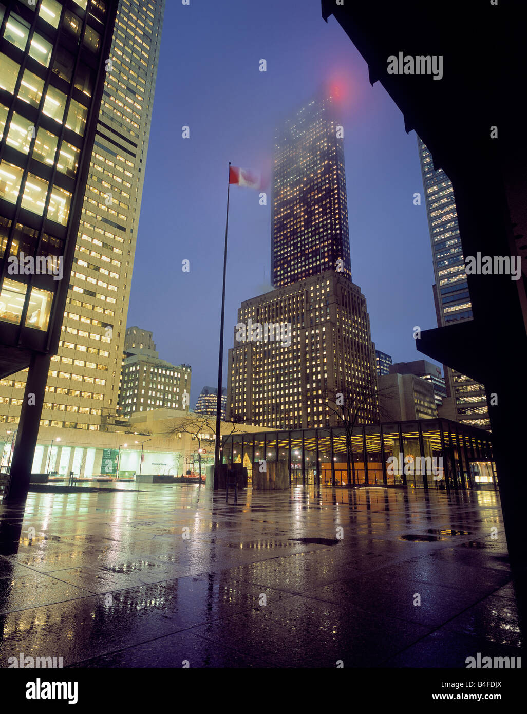 Wet square with illuminated offices and the Canadian flag, Toronto ...