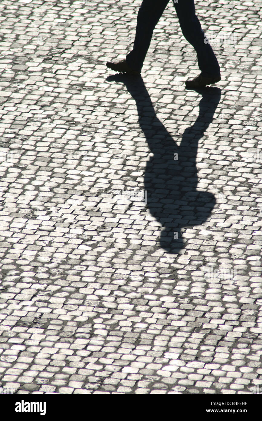 one person walking on cobbled street in city town Stock Photo - Alamy