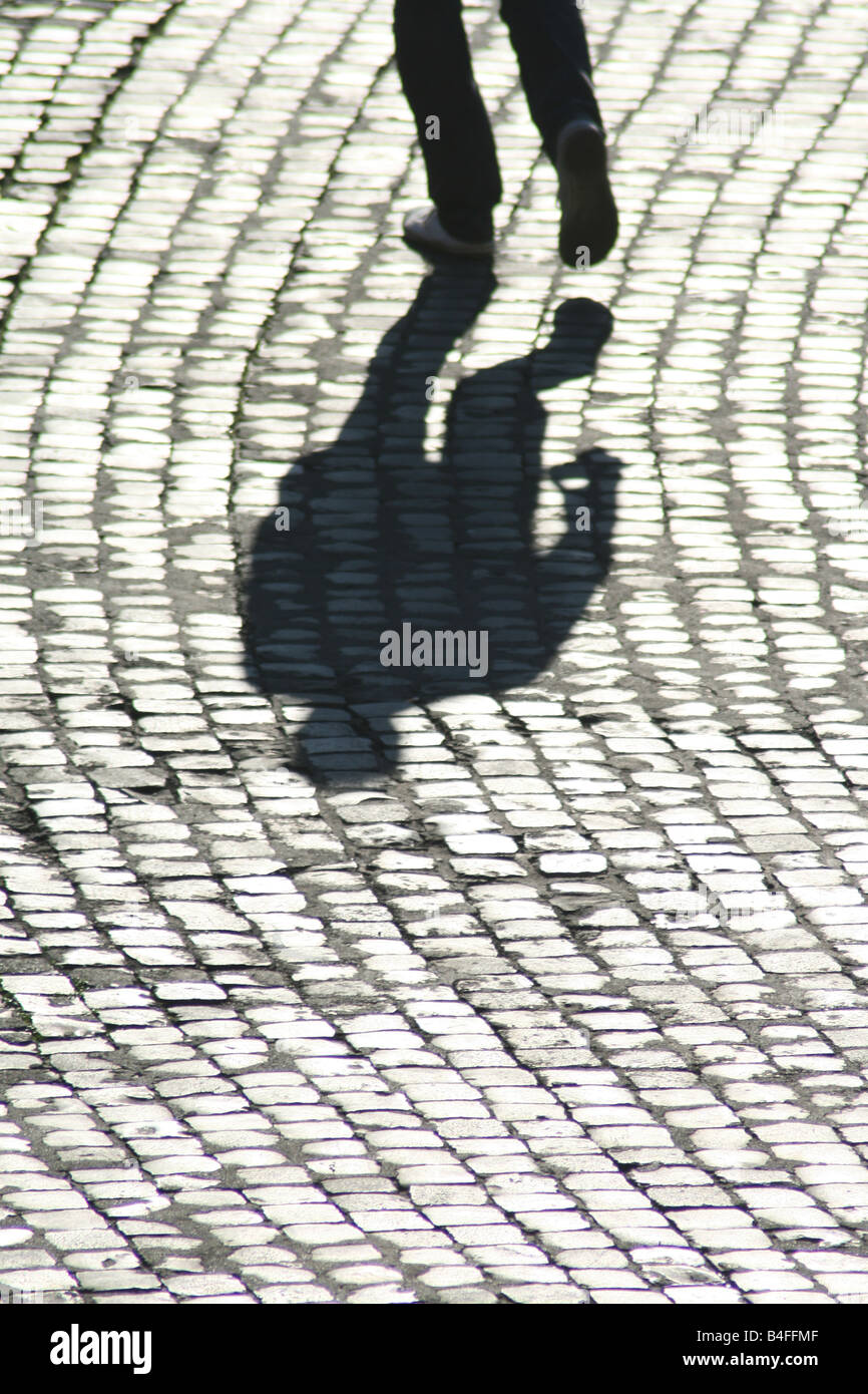 one person walking on cobbled street in city town Stock Photo - Alamy