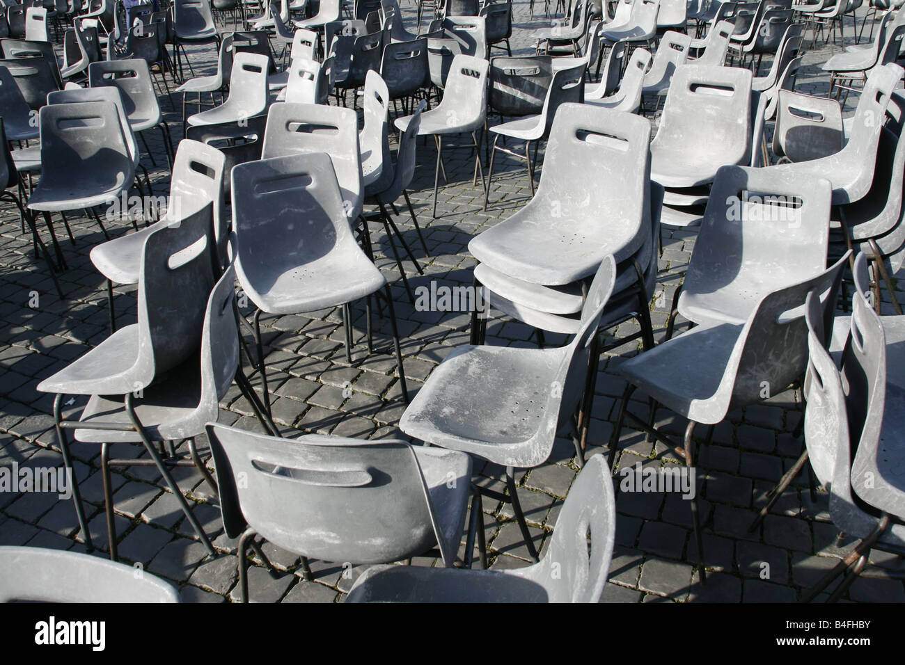rows of stacked and jumbled gray plastic chairs Stock Photo - Alamy