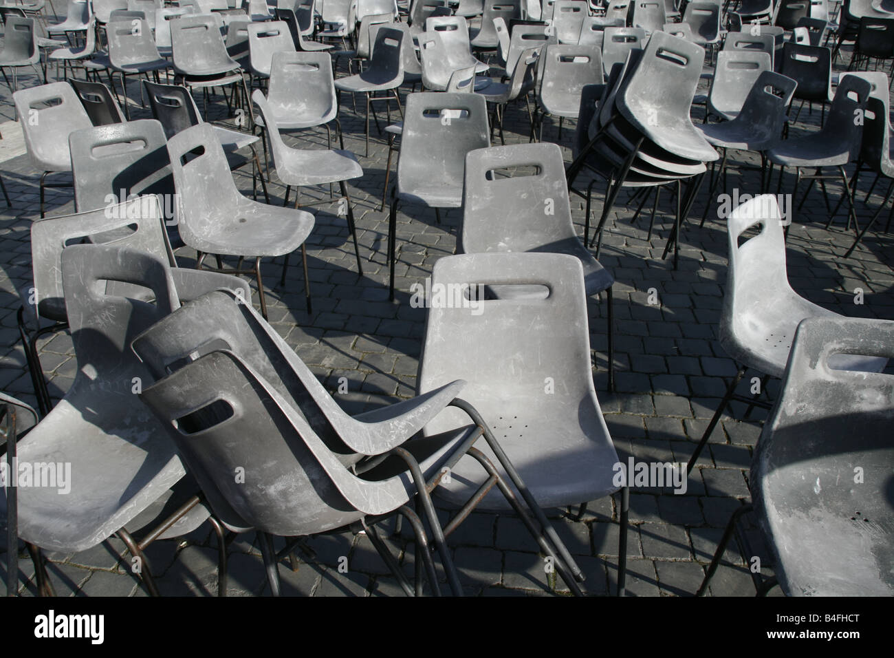 rows of stacked and jumbled gray plastic chairs Stock Photo - Alamy