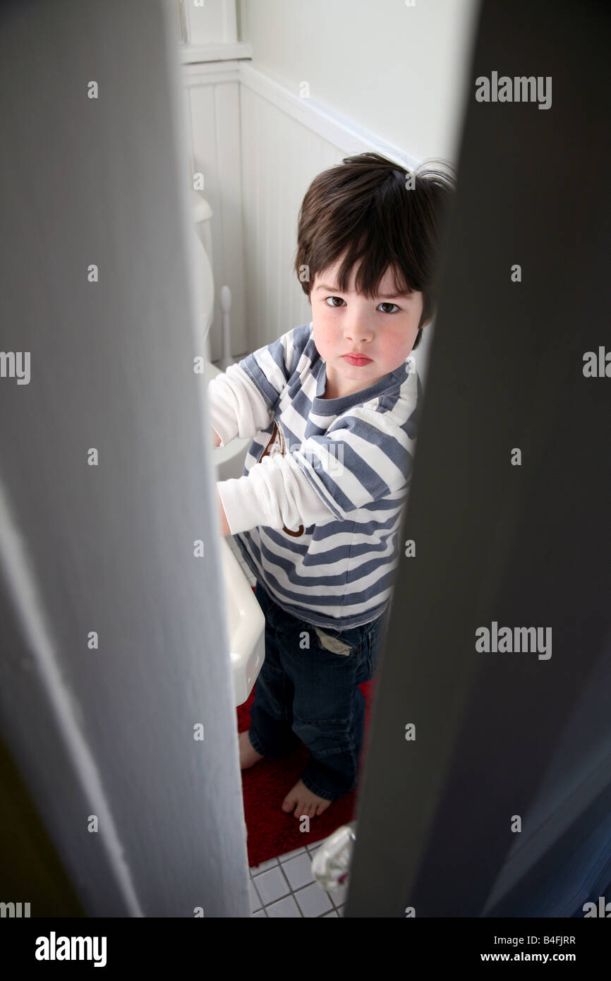 Boy washing hands, viewed through crack in bathroom door Stock Photo ...