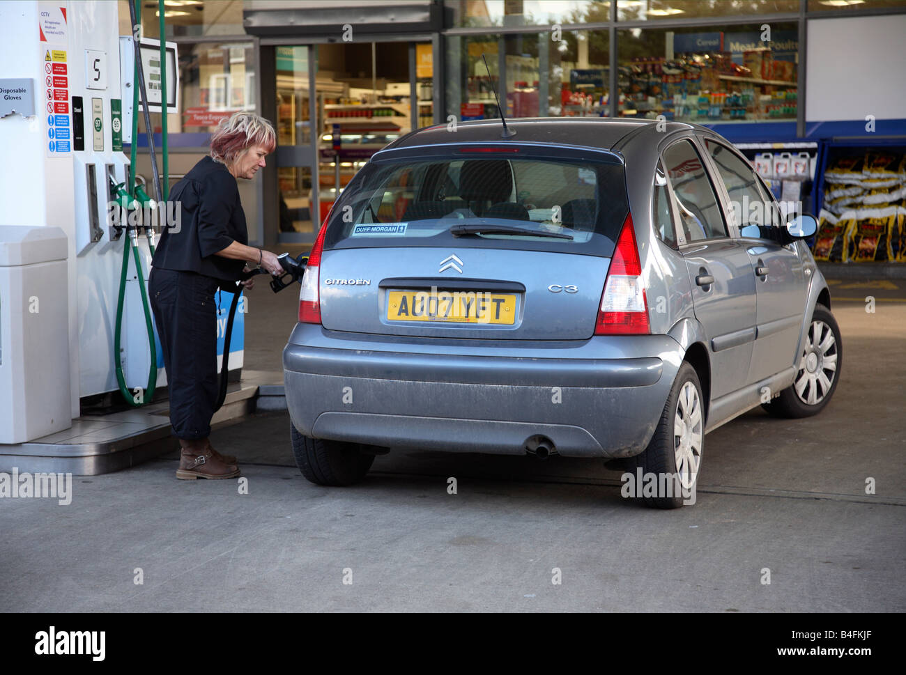 Woman filling her car up at a petrol station Stock Photo - Alamy