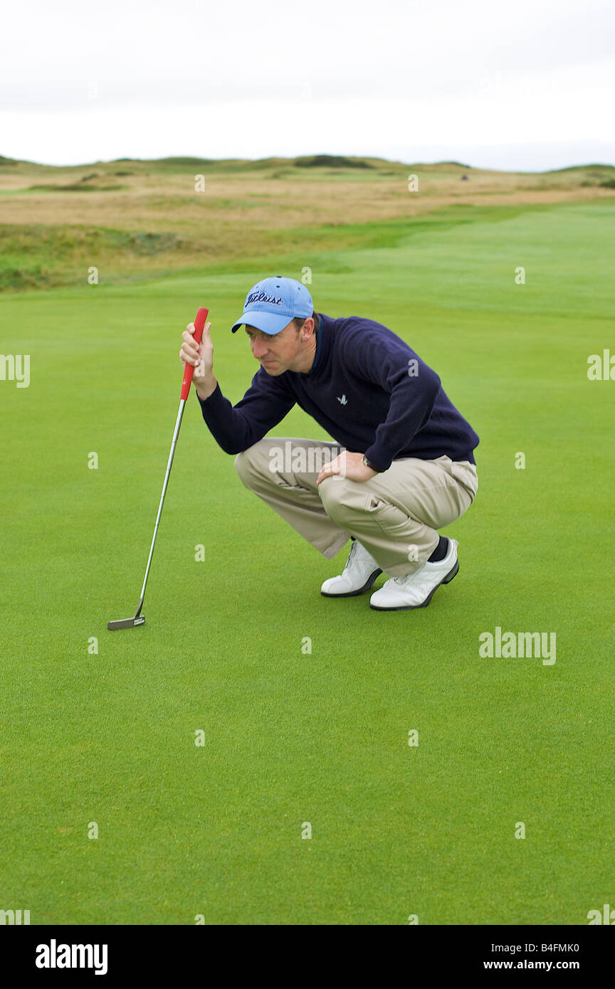 Professional golfer lining up a putt on the green (part of a series Stock Photo - Alamy