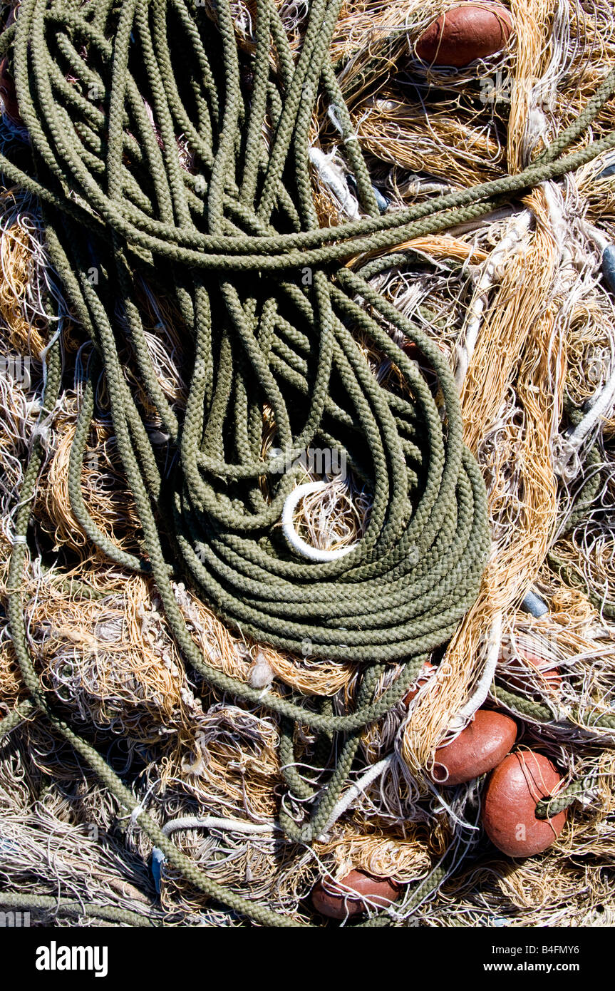 Fishing nets piled on a dock side Stock Photo - Alamy