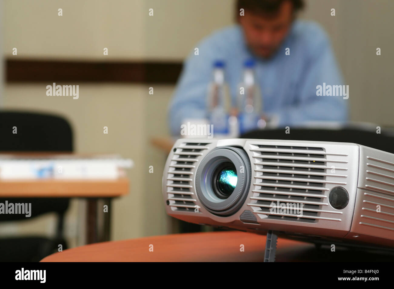 Projector on table with person behind (horizontal Stock Photo - Alamy