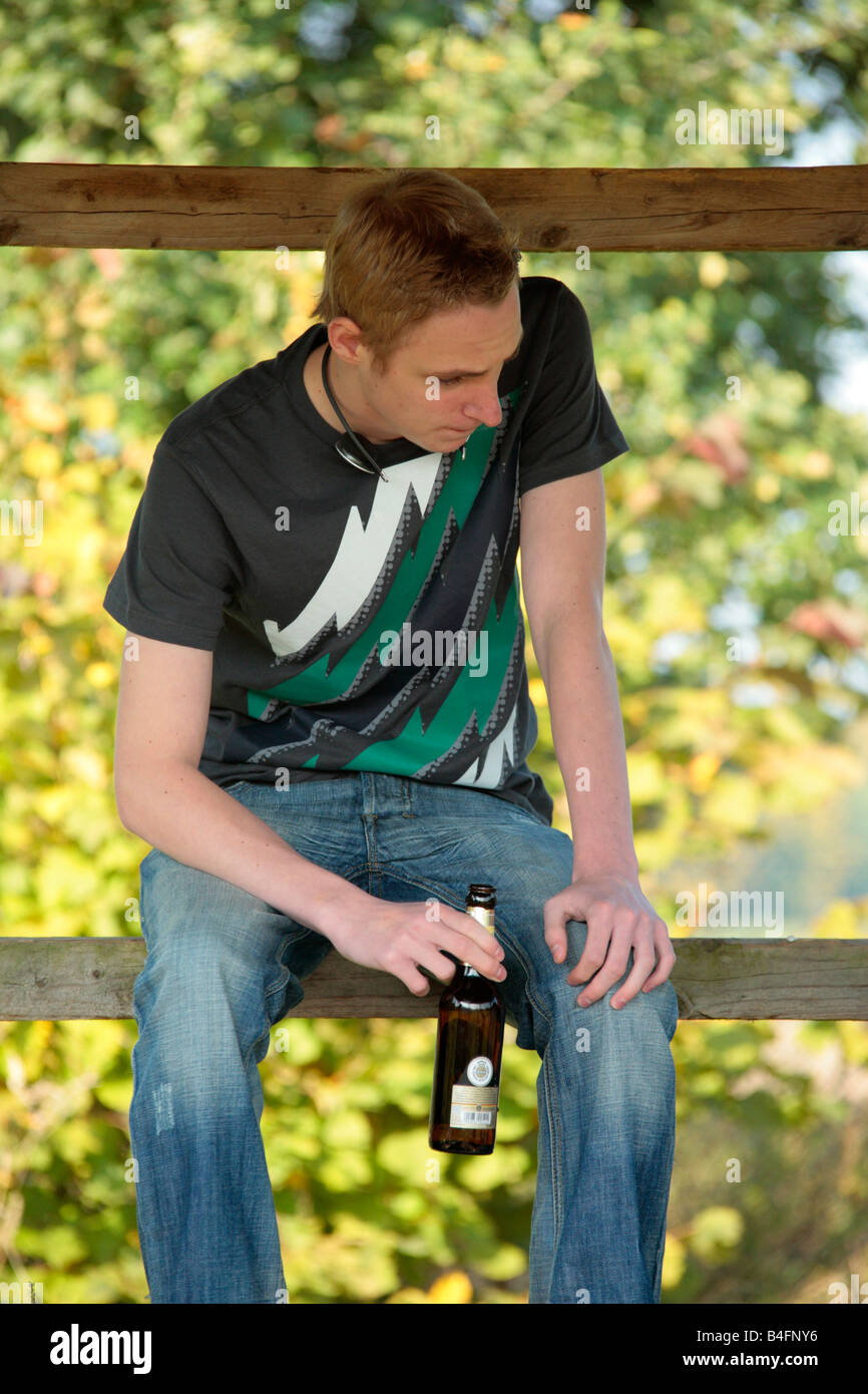 Portrait of a teenage boy drinking beer. The picture is being posed ...