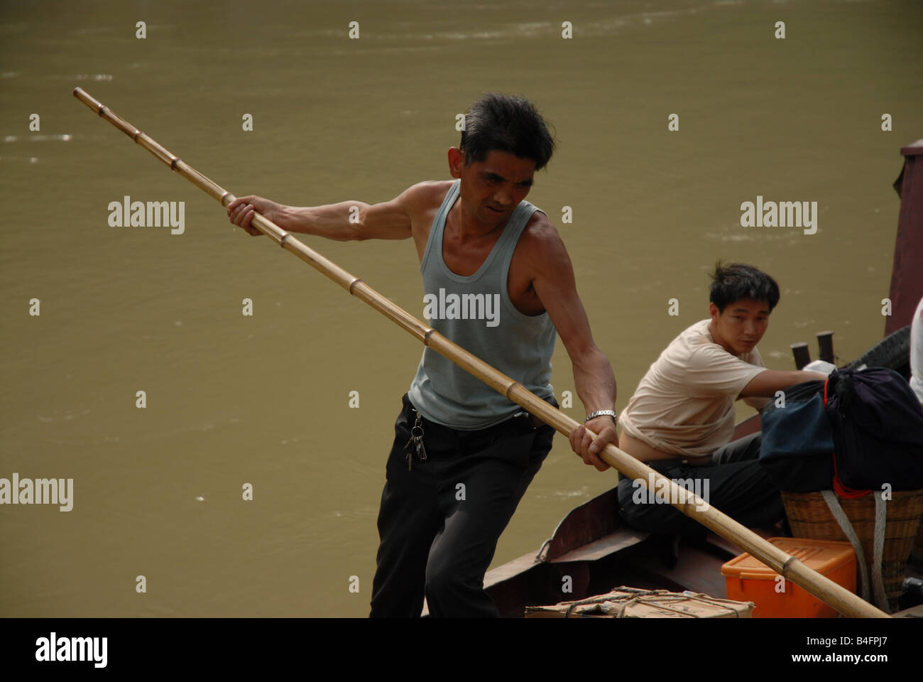 A deckworker helps a riverboat into dock along the Wu River in rural ...