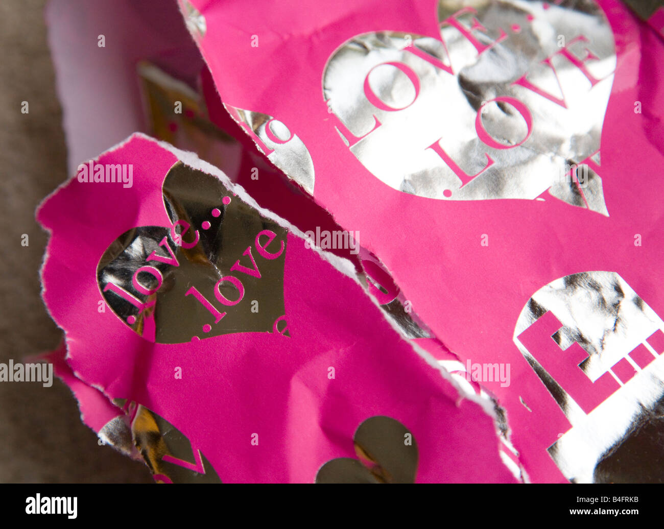 A present. Torn pink wrapping paper with silver hearts Stock Photo - Alamy