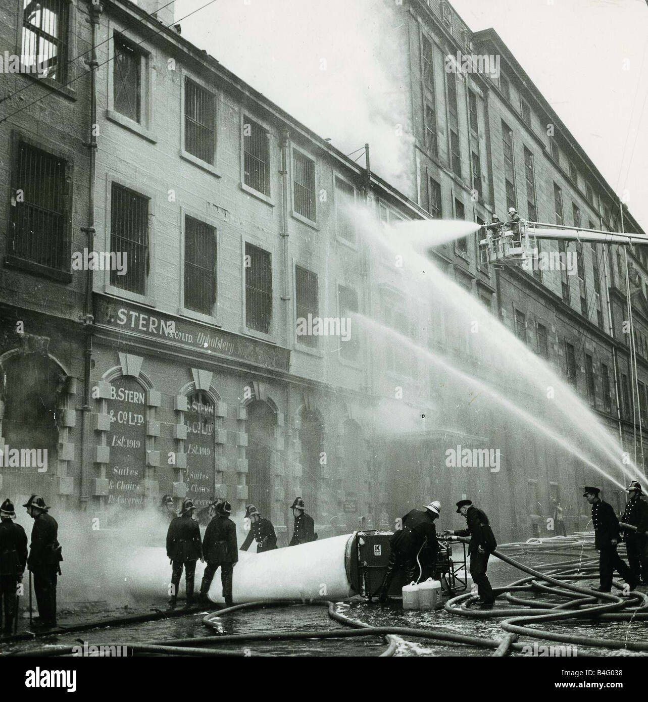 Firemen hosing down a building after a warehouse fire on James Watt ...