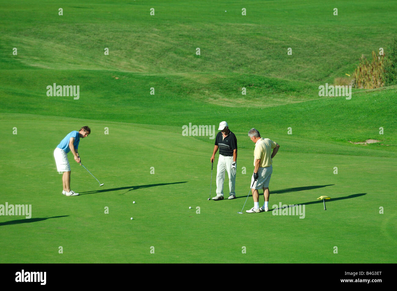 Three golf players competing on the green golf course – France Stock ...