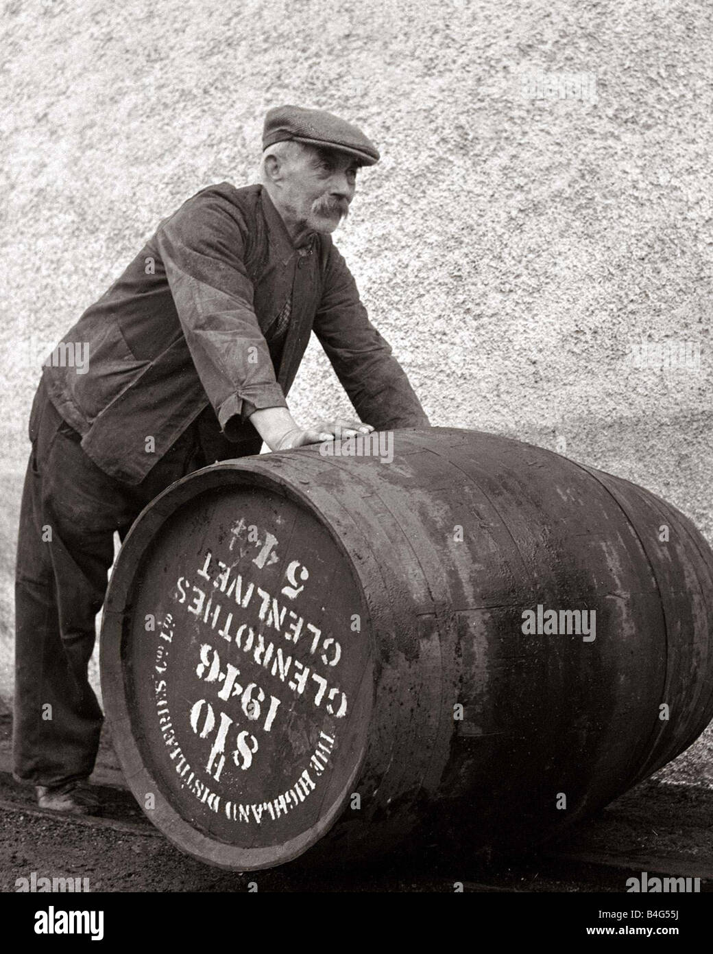 A Glenlivet Distillery worker in Scotland rolls a barrel of their ...