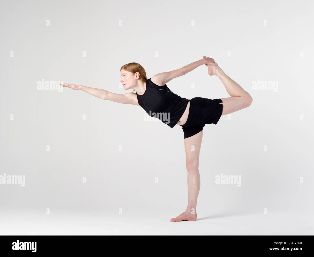 A young woman practicing the 'Shiva' yoga pose Stock Photo - Alamy