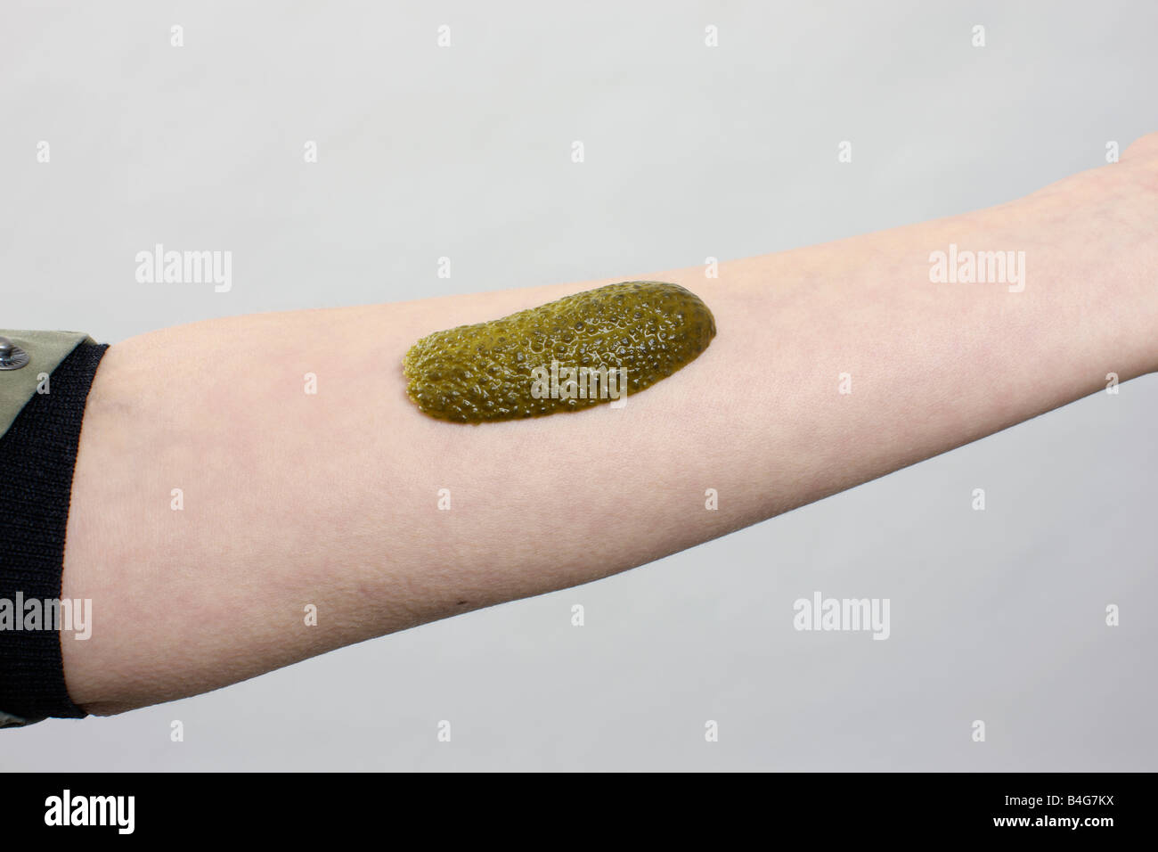 A human arm with half a pickle on it representing a leech Stock Photo ...