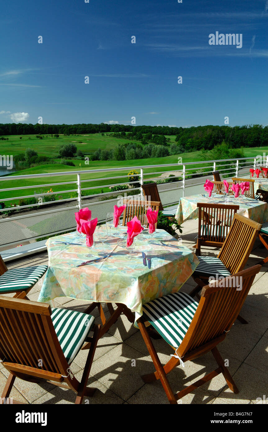 Restaurant tables with overview on background to a green golf course ...