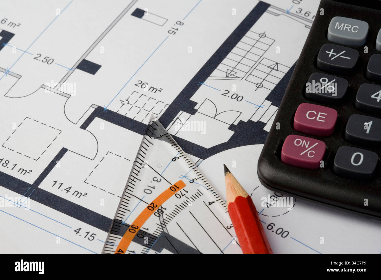 A ruler, pencil and calculator on top of a building plan, close-up ...
