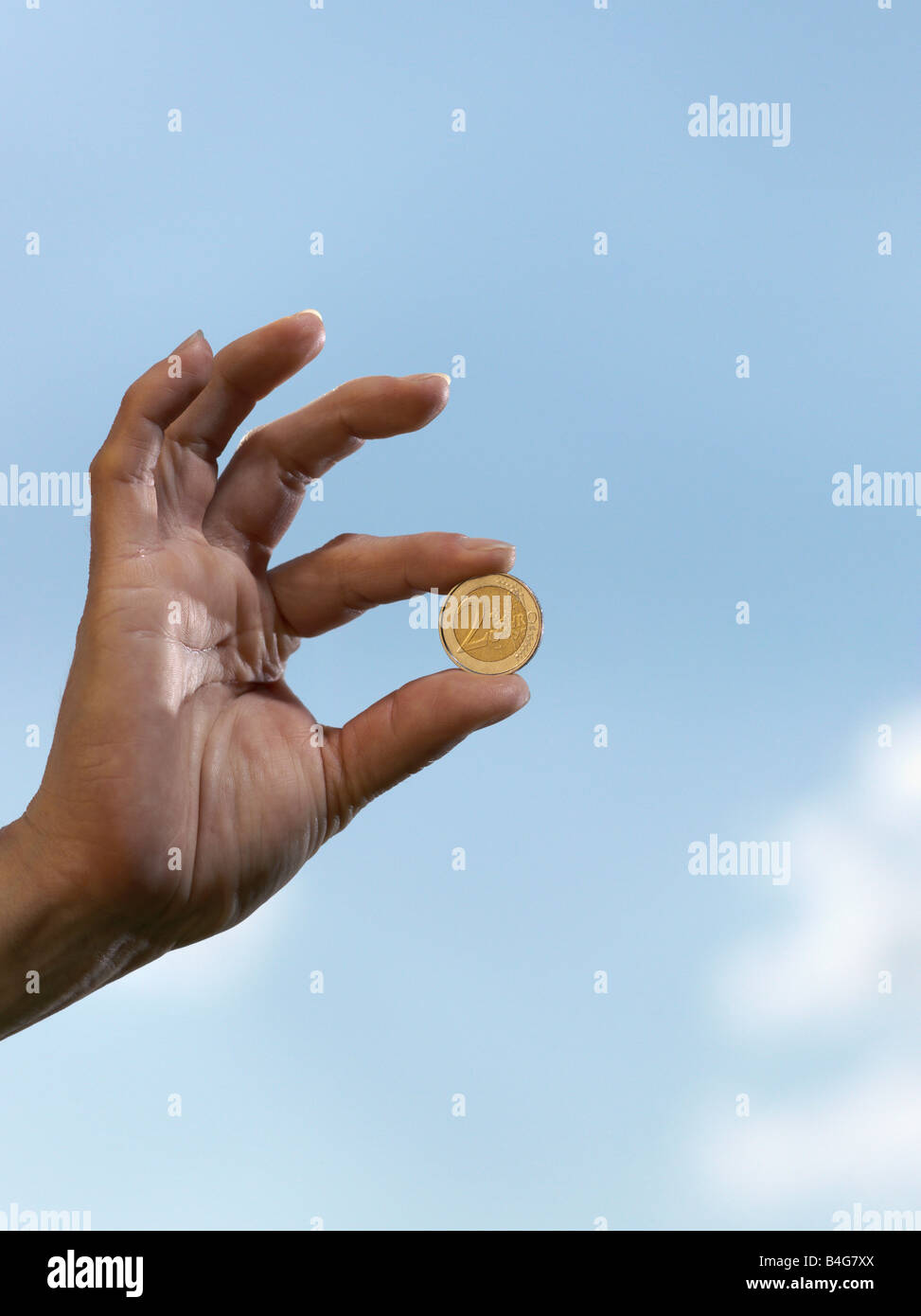A human hand holding a two euro coin Stock Photo - Alamy