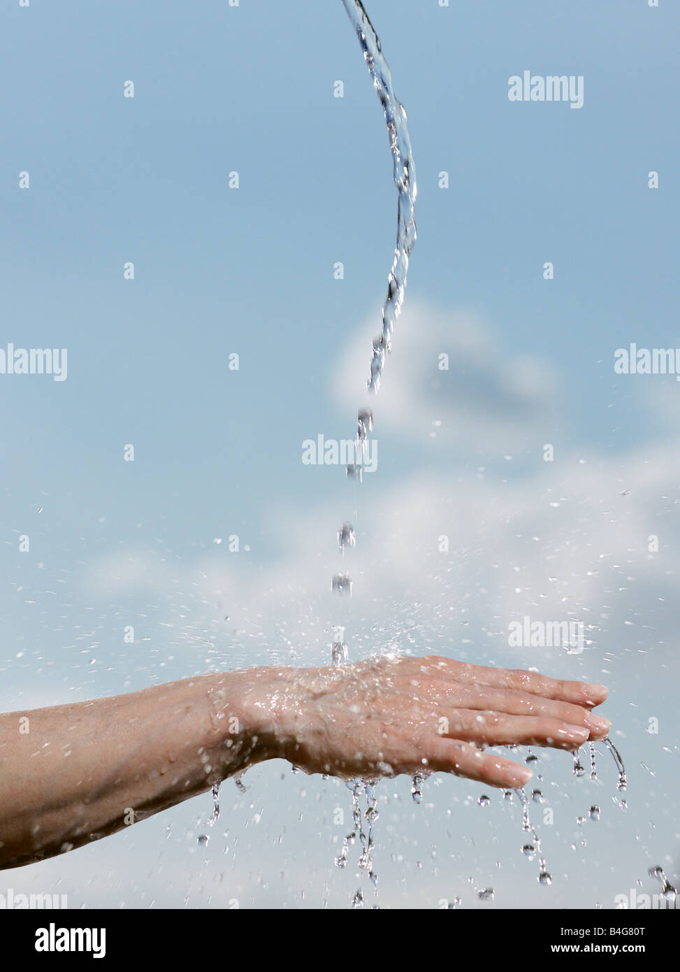 Water pouring onto the back of a person's hand Stock Photo - Alamy