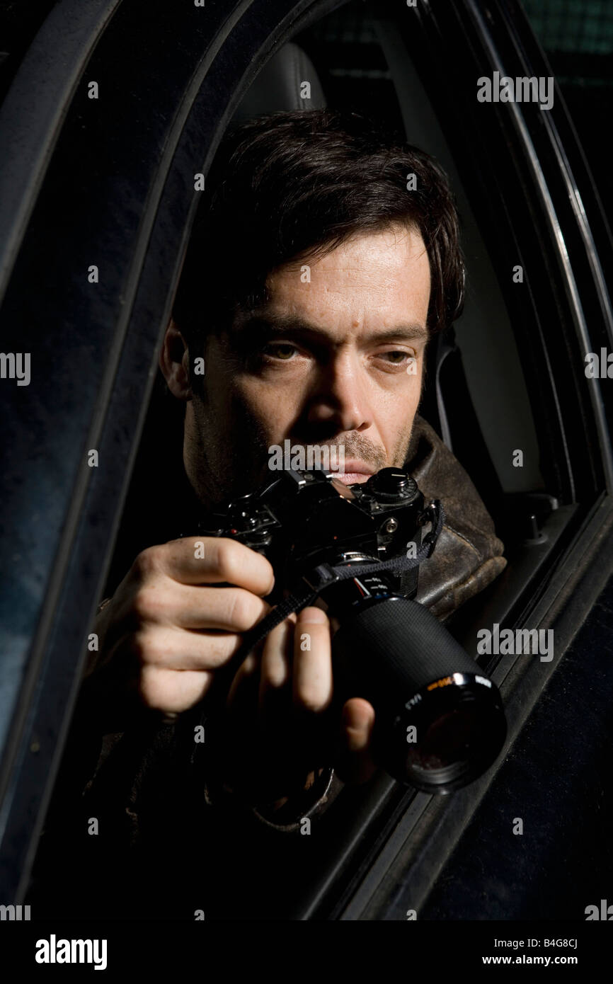 A man doing surveillance with a camera from his car Stock Photo - Alamy