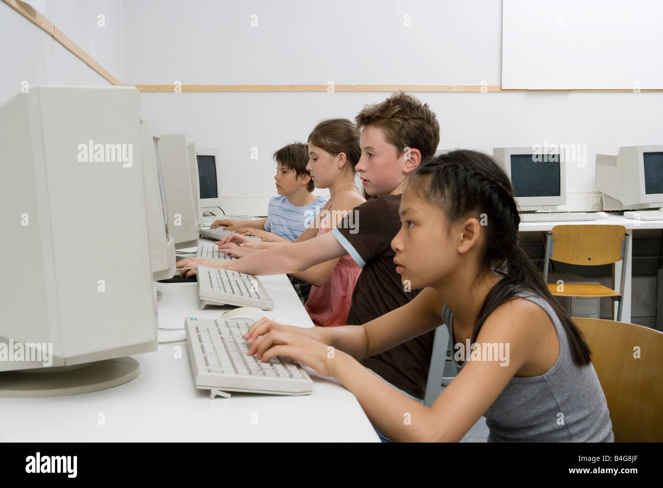 Four pre-adolescent children in a computer lab Stock Photo - Alamy