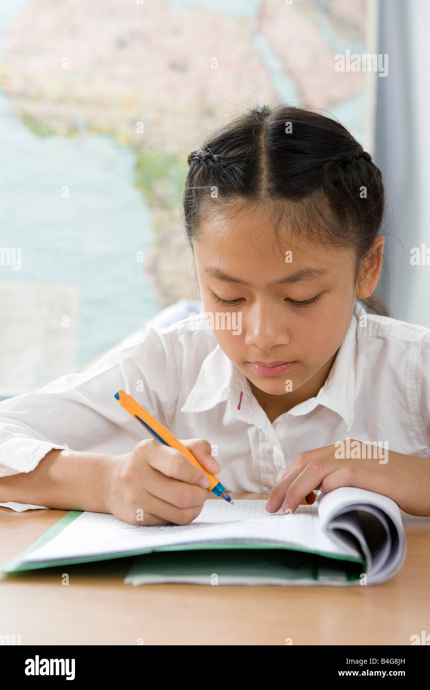 A pre-adolescent girl studying in a classroom Stock Photo - Alamy