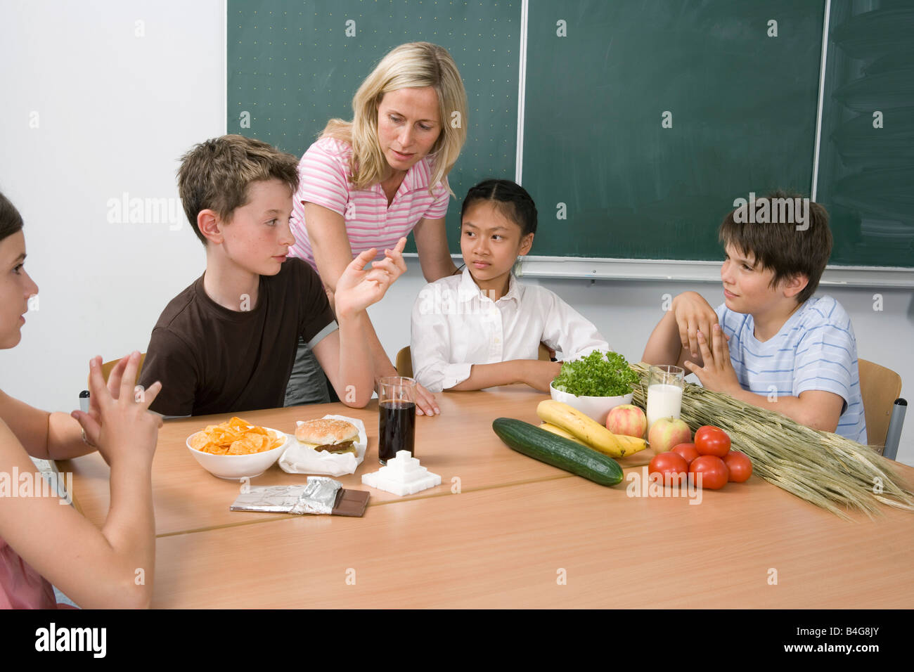 A teacher and four students learning about nutrition Stock Photo - Alamy