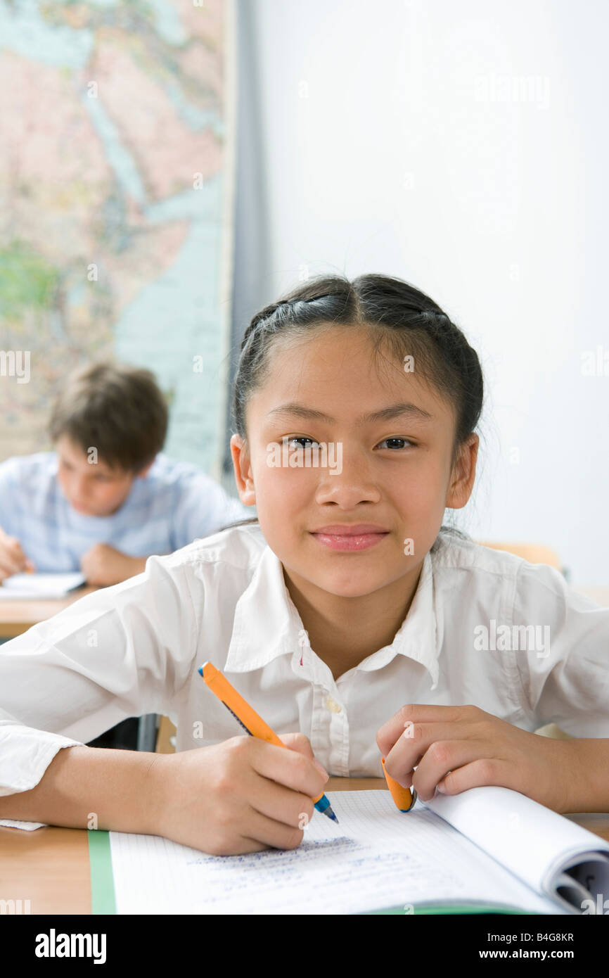 A pre-adolescent girl studying in a classroom Stock Photo - Alamy