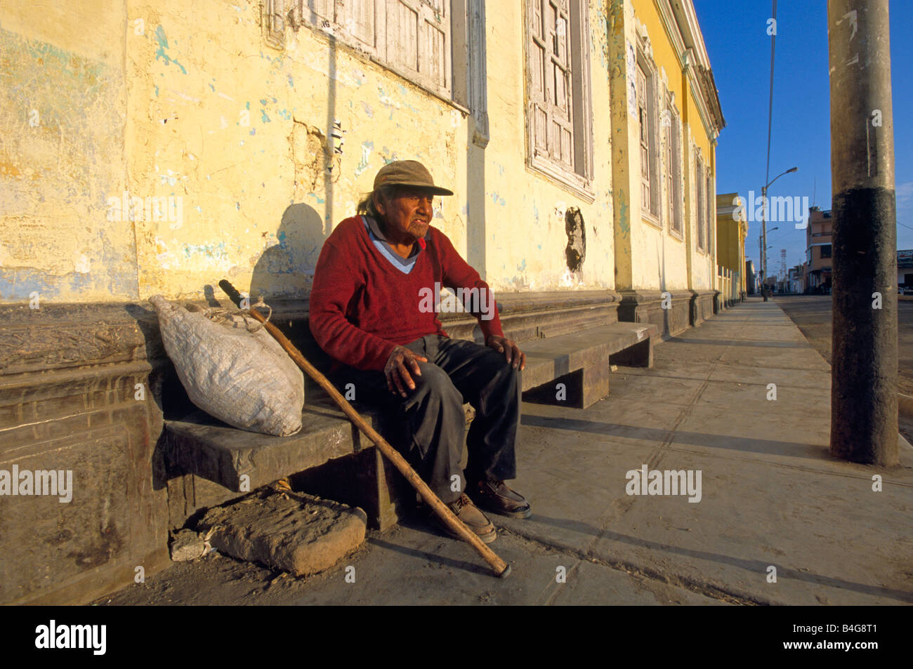 A local poor old man sitting in the late afternoon sun on one of the ...