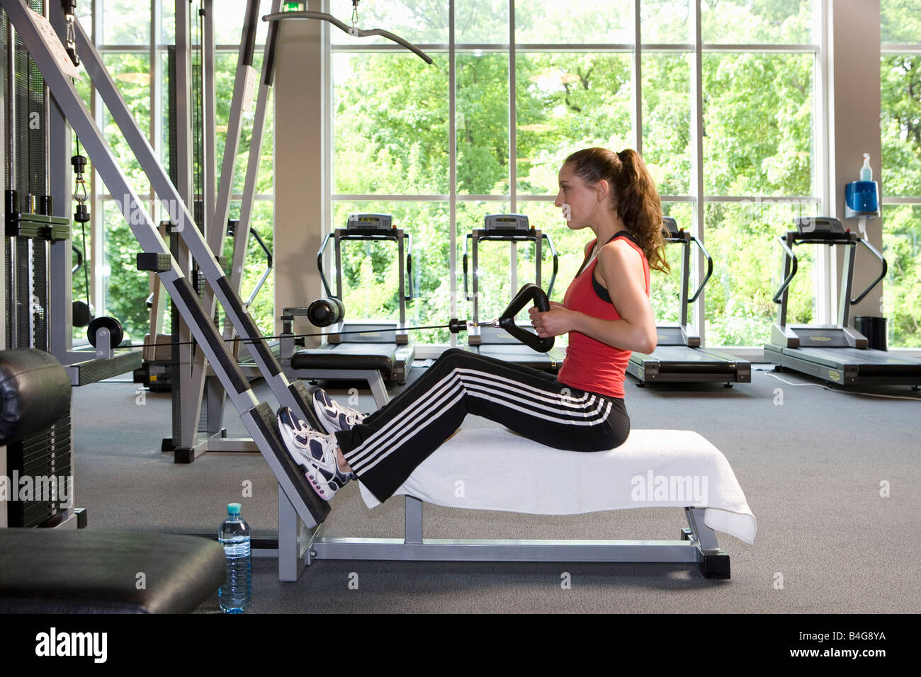 A woman using a weight machine Stock Photo - Alamy