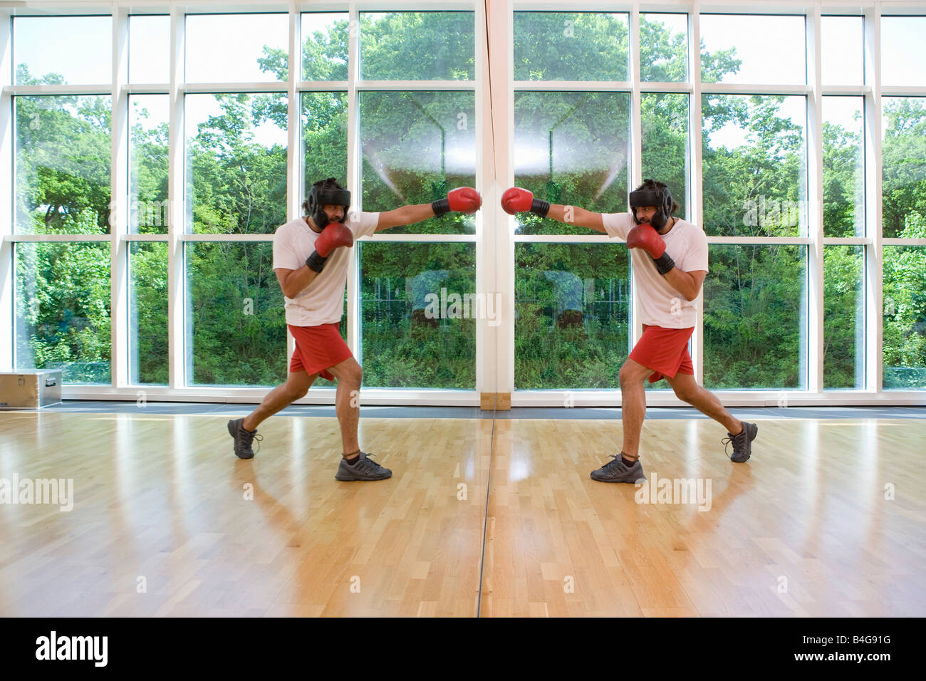 A man boxing his mirrored reflection Stock Photo - Alamy