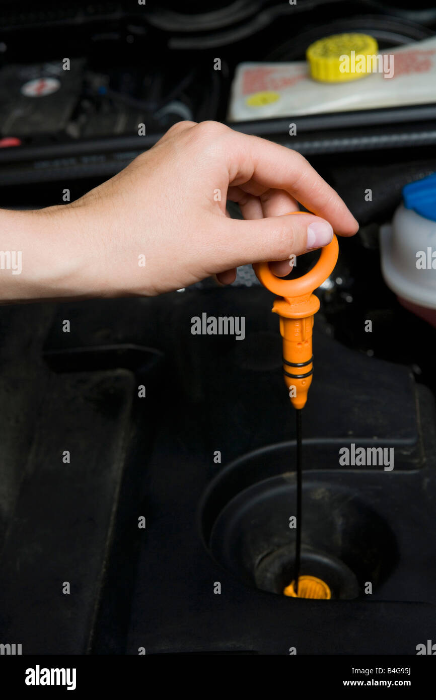 A person checking the oil in a car engine Stock Photo - Alamy